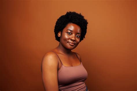 갈색 배경 라이프 스타일 사람들 개념에 쾌활한 몸짓을 포즈 곱슬 머리를 가진 예쁜 젊은 아프리카 계 미국인 여자 아프리카 민족에 대한 스톡 사진 및 기타 이미지 Istock