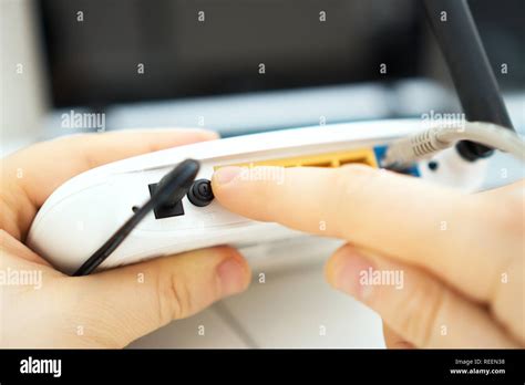 Man Pressing Power Button On The Wifi Router Stock Photo Alamy