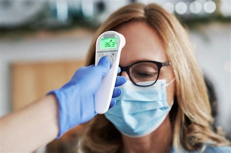 Premium Photo Close Up Of Using Thermometer Gun To Check Body Temperature