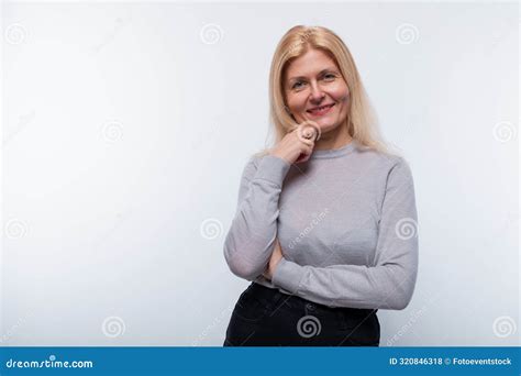 Modest Mature Blonde Woman Wearing A Gray Turtleneck Looking At The Camera Stock Photo Image
