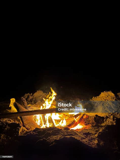 모래 구멍에 해변 모닥불에서 춤추는 불꽃의 이미지 밤하늘을 배경으로 모래 구덩이에서 나무를 태우고 전경에 초점을 맞추고 공간을 복사합니다 0명에 대한 스톡 사진 및 기타