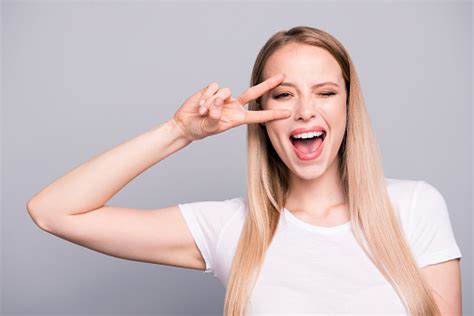 넓게 열린된 입으로 Vsign 제스처를 보여주는 젊은 금발의 화려한 예쁜 여자의 초상화 회색 배경 위에 절연 경외감에 대한 스톡 사진 및 기타 이미지 Istock