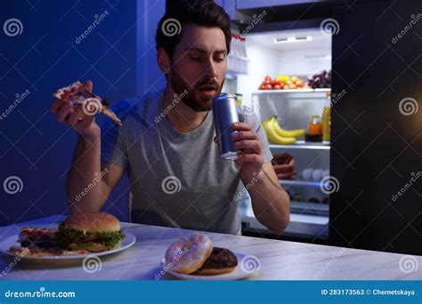 Man Drinking Soda And Eating Junk Food In Kitchen At Night Bad Habit