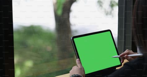 디지털 태블릿의 녹색 화면에 스타일러스 펜을 사용하는 클로즈업 여성 사진 Unsplash의 비즈니스웨어 이미지