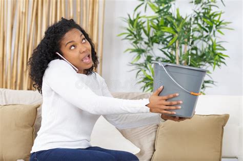 Woman Calling Plumber To Fix Water Leaking From Ceiling Stock Image