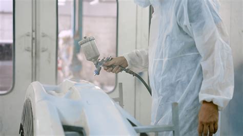 오염을 방지하기 위해 Ppe를 착용하는 백인 스프레이 룸에서 작업하는 안전을 위해 공기 스프레이 페인트를 사용하여 남자의 손을