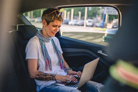 여름날 노트북 컴퓨터에서 일하는 자동차 뒷좌석에 앉아있는 성숙한 여성 백인 여성 한 명과 짧은 회색 머리 현대 관리자 또는 캐주얼 카피 공간을 착용하는 도로의 비즈니스