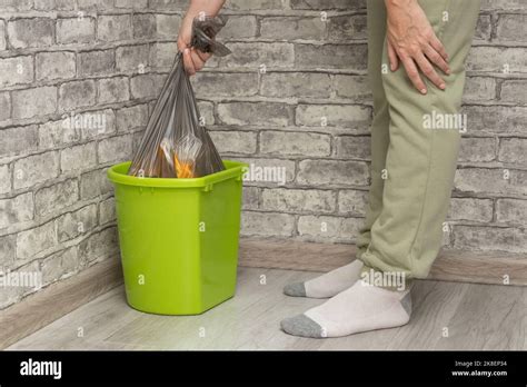 A Man Takes A Bag Of Garbage Out Of A Bucket The Hostess Changes The Garbage Bag Stock Photo