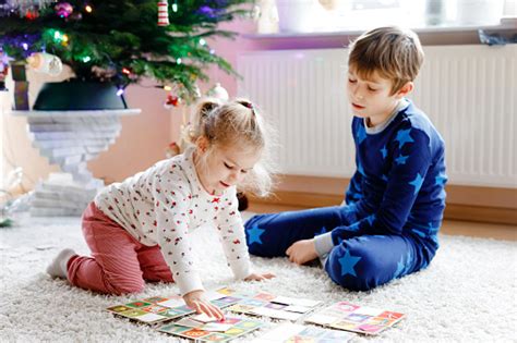 두 개의 작은 칠렌 귀여운 유아 소녀와 학교 아이 소년 장식 크리스마스 트리에 의해 카드 게임을 함께 재생 행복한 건강한 형제 자매 형제 자매는 함께 즐거운 시간을 보내고