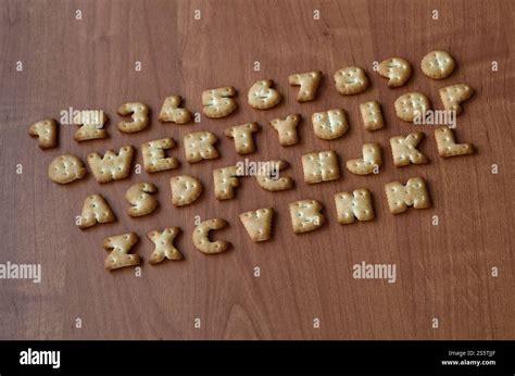 Letters Of Salty Crackers Lay On A Wooden Brown Surface In The Order Similar To The Layout Of