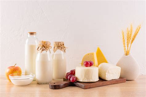 보드에 다양한 종류의 치즈 우유 병 코티지 치즈 사워 크림 나무 테이블에 빵 귀 다발 샤부옷 휴일 Shavuot에 대한 스톡