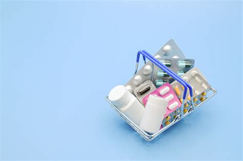 구매 및 쇼핑 의학 개념 파란색 배경에 상점 바구니에 다양한 캡슐 정제 및 의약품이 있습니다 건강 관리 건강 보험 및 제약 회사를위한 창의적인 아이디어 복사 공간 개념에