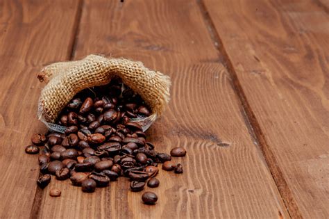 신선한 볶은 커피 원두가 나무 표면의 자루에 떨어집니다 식탁에 가방에서 흩어져 있는 브라운 커피 콩 0명에 대한 스톡 사진 및 기타 이미지 Istock