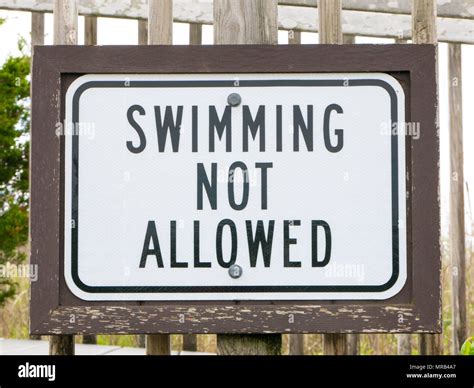 An American Warning Sign At The Beach With Man Swim And Not Symbol