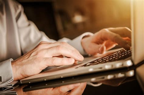 Premium Photo Man Sitting At Desk And Working On Computer