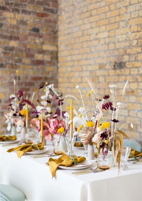 The Table Is Set With Flowers In Vases And Place Settings For Four People To Sit At