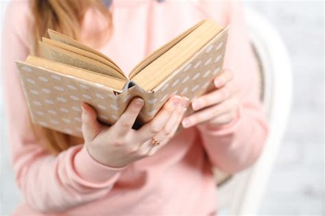 Primer Plano De Mujer Con Libro De Tapa Roja En Las Manos Foto Gratis