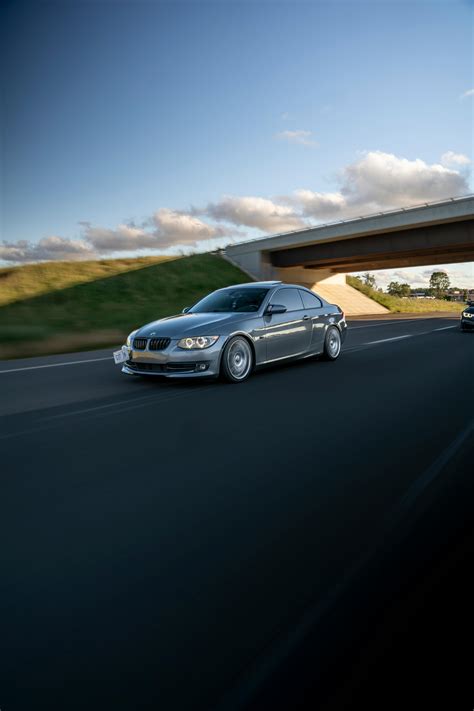 개방된 도로를 질주하는 세련된 흰색 자동차 · 무료 스톡 사진