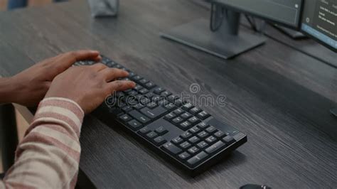 Closeup Of African American Programer Hands Typing Code On Keyboard While Looking At Computer