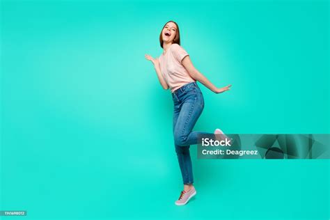 전체 길이 측면 프로필 몸 크기 사진 아름 다운 펑키 그녀의 그녀는 여자 예쁜 외모 이상한 이동 모션 착용 캐주얼 청바지 데님 파스텔 티셔츠 옷 고립 된 청록 청록색 배경