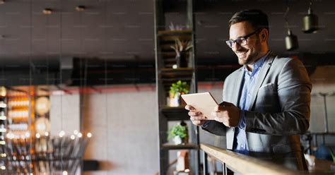 태블릿을 사용하여 현대 사무실에서 양복을 입은 행복한 젊은 사업가 사진 Unsplash의 양복 이미지