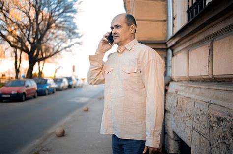 휴식 중에 사무실 건물 앞에 서있는 성인 남성이 휴대 전화로 이야기합니다 T 셔츠에 대한 스톡 사진 및 기타 이미지 T 셔츠 개념 거리 Istock