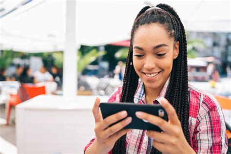 카페테리아에서 커피를 마시고 스마트 폰을 사용하여 미소 짓는 아프로 여성 20 24세에 대한 스톡 사진 및 기타 이미지 20 24세 Brand Name Online