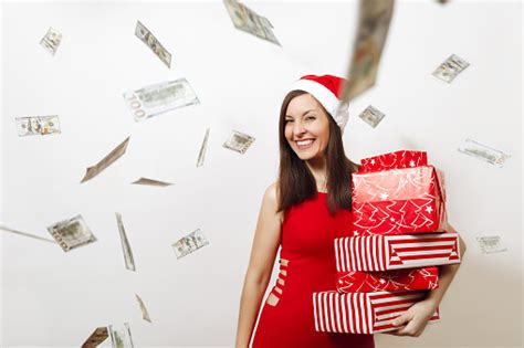 빨간 드레스와 크리스마스 모자 흰색 배경에 선물 상자와 돈 지폐를 들고 꽤 백인 젊은 행복 한 여자 현재와 산타 소녀와 격리 하는 현금입니다 새 해 휴일 2018 개념