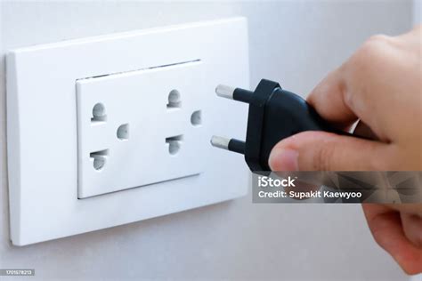 손 잡고 있는 플러그는 벽 전원 콘센트 소켓 절전 개념 에너지 절약 에너지 절약의 전기 콘센트에 전원 플러그에 연결합니다 가계에