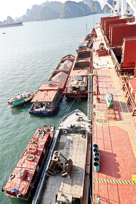Loading Bulk Cargo Of Limestone From Barges Into A Bulk Carrier By Using Ship Cranes And Grabs