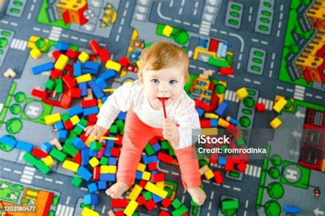 교육 장난감을 가지고 노는 사랑스러운 아기 소녀 집에서 집에서 다채로운 다른 나무 블록으로 재미있게 즐거운 건강한 아이 아기 학습 색상과 형태 개발에 대한 스톡 사진 및