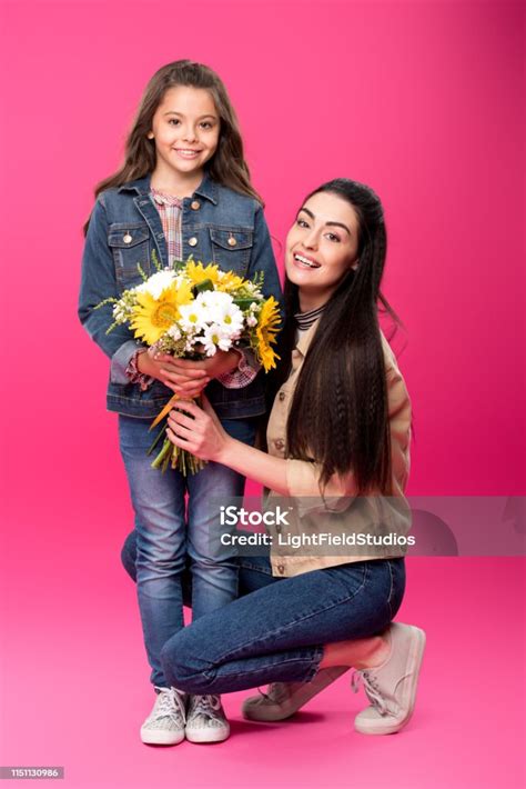 핑크에 카메라에 미소 꽃 부케와 함께 행복 한 젊은 어머니와 사랑 스러운 딸의 전체 길이 보기 2명에 대한 스톡 사진 및 기타 이미지 Istock