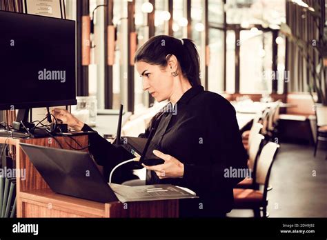 Female Owner Adjusting Wire Of Computer Monitor In Cafe Stock Photo Alamy