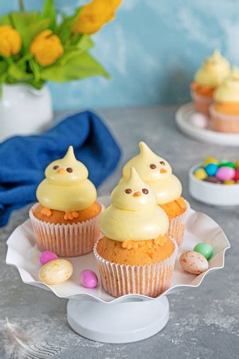 귀여운 부활절 병아리 컵 케이크 흰색 나무 배경에 신선한 꽃이 있는 흰색 스탠드에 버터크림을 곁들인 바닐라 컵케이크 공간을 복사합니다 부활제에 대한 스톡 사진 및 기타