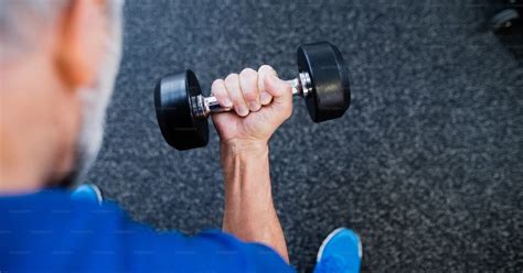 체육관에서 운동복을 입은 알아볼 수 없는 노인이 웨이트로 운동하고 있습니다 사진 Unsplash의 운동 이미지