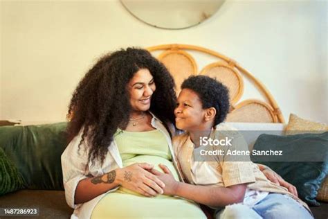 아이와 함께 배와 임산부를 안고 아기를 차고 움직임을 느낀다 미소 행복 그리고 집에서 태어나지 않은 아이를 느끼기 위해 임신 중에 배를 만지는 소년 아이를 둔 어머니 25