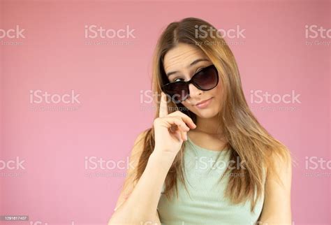 진지한 제스처와 생각으로 분홍색 고립 된 배경 위에 서 있는 선글라스를 착용한 젊은 아름다운 여성 그녀는 질문이 있습니다 귀여운에 대한 스톡 사진 및 기타 이미지 Istock
