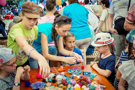젊은 여자화려한 테이블 냅킨을 뜨개질을 하는 방법을 설명 하는 자원 봉사 가족에 대한 스톡 사진 및 기타 이미지 가족 공예 냅킨 Istock