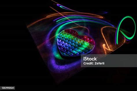 아이들은 안티 스트레스 감각이 검은 테이블이나 바닥 배경에 장난감을 밀어 또는 간단한 보조개 안절부절 팝 팝 무지개 색조 밝은 색상 트렌드 2021 년 상단 보기 플랫 레이