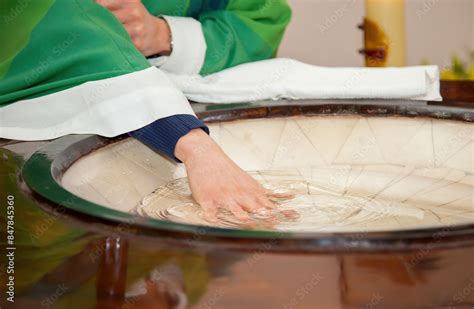 Priest In Green Liturgical Vestments Blessing Holy Water In A Marble