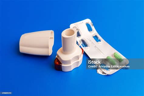 흡입기 및 약이 든 캡슐 Copd 또는 천식 캡슐 흡입기 파란색 고립 배경에 있습니다 천식 예방을 위한 흡입기 또는 기관지 확장제 및 의료용 분말 캡슐 0명에 대한 스톡