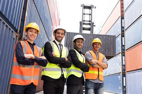 눈에 잘 띄는 조끼와 안전모를 쓴 선적장에서 행복한 노동자 4명이 웃으며 사업을 하고 있다 건설 산업에 대한 스톡 사진 및 기타 이미지 건설 산업 건설 현장 건설업자