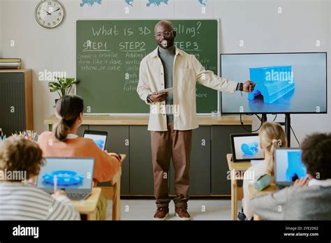 African American Teacher Demonstrating 3d Modeling Techniques In Front