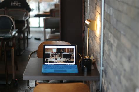 검은색 세라믹 머그잔 근처 테이블 위에 켜진 파란색과 검은색 노트북 컴퓨터 사진 Unsplash의 무료 테이블 이미지