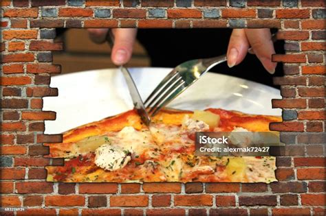 깨진된 벽돌 벽과 인간의 손에 포크와 나이프 절단 맛 있는 피자를 피자에 대 한 간판 건축자재에 대한 스톡 사진 및 기타 이미지 건축자재 고기 구멍 Istock