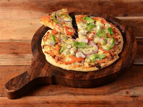 Premium Photo Veg Pizza On Wooden Pizza Board Isolated Over A Rustic