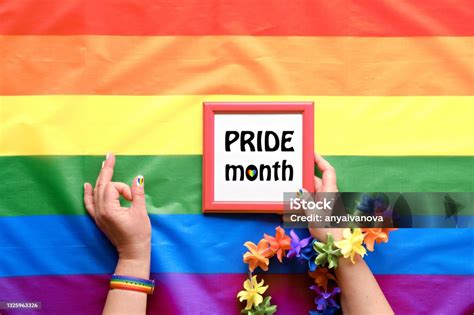텍스트 프라이드의 달 간단하고 최소한의 Lgbt 자부심 장식 손목 밴드와 활기찬 꽃 화환 무지개 페인트 손톱과 손 배경으로 무지개 의 색상에 플래그 최고 보기 최소한의