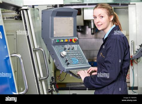 female engineer operating computer controlled cutting machine stock