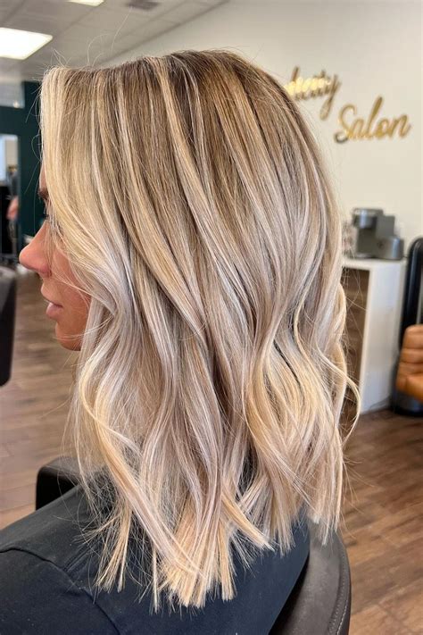 Medium Length Layered Cut With Soft Waves Featuring A Blend Of Honey