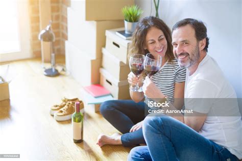 중년 노인 로맨틱 한 부부는 주위에 상자와 아파트 바닥에 앉아 사랑에 새로운 집으로 이동행복 미소 와인 한 잔을 마시는 축하 2명에 대한 스톡 사진 및 기타 이미지 Istock